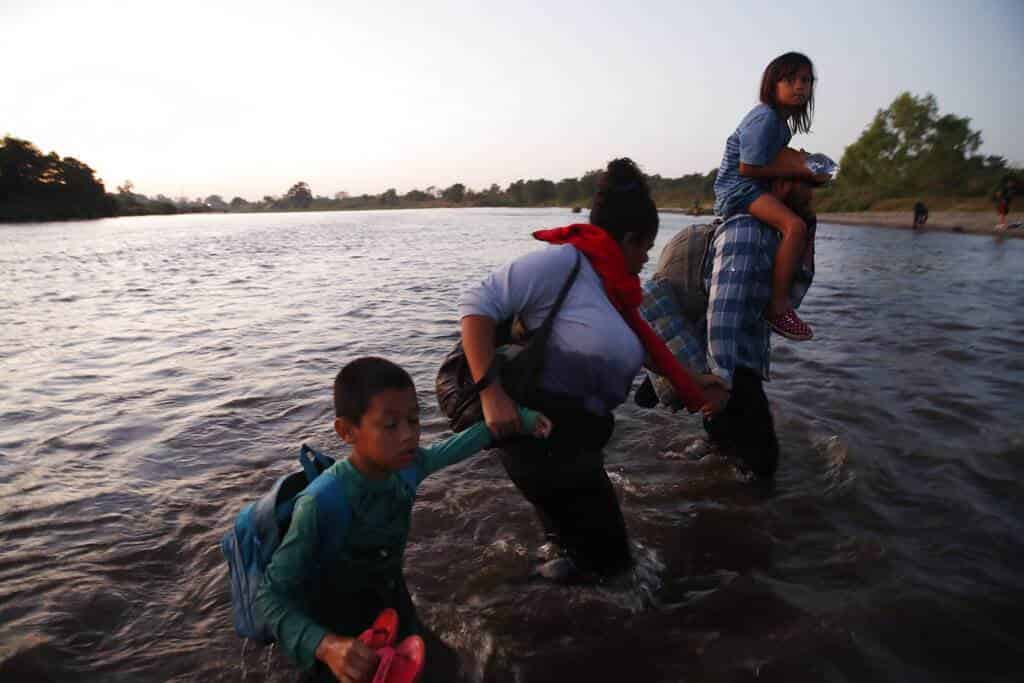 Cientos de migrantes cruzan en grupo el río Suchiate hacia México